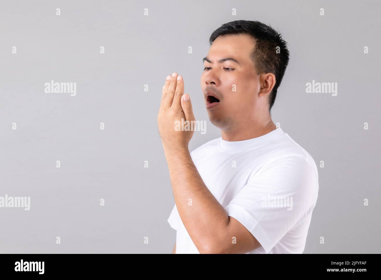Health Care : Man checking his breath with hand. Portrait asian man are ...