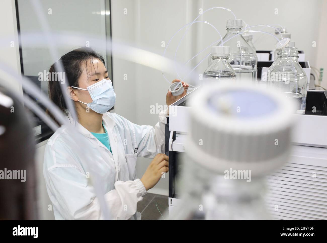 A researcher from a pharmaceutical company performs an experiment in a ...