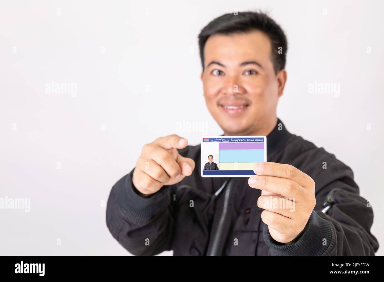 Portrait rider in black jacket holding and show blank of Thailand ...