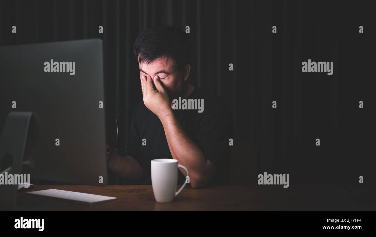 Eyestrain concept. Man touching his eyes because tired after working ...