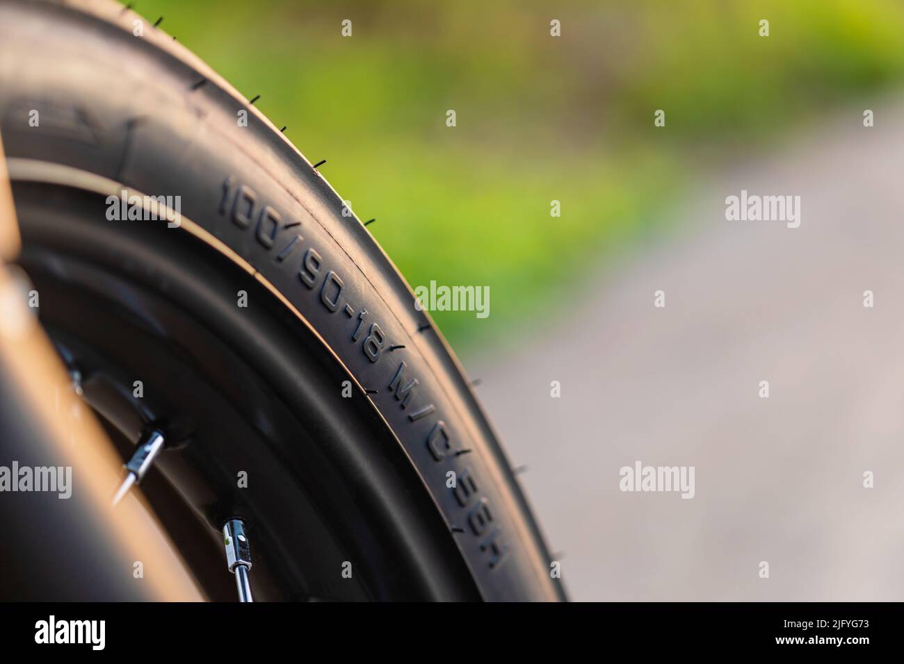 Macro number code on the front motorcycle rubber wheel. Outdoor ...