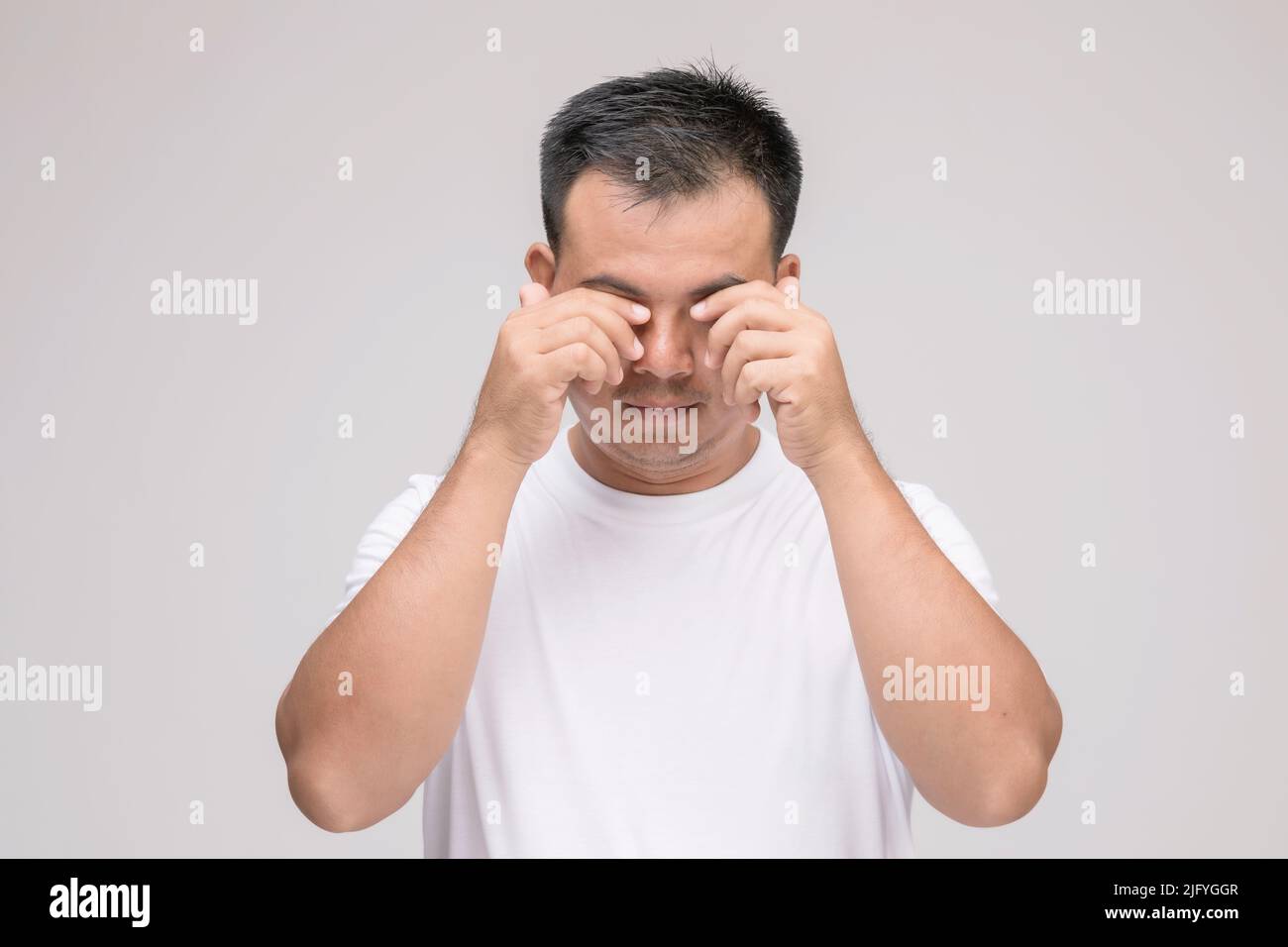 Eye irritation concept : Portrait of Asian man in posture of eye tired ...