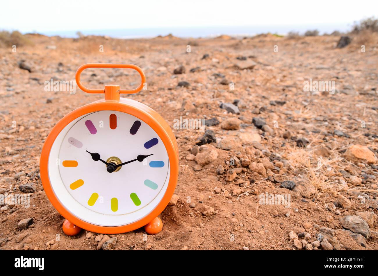 Classic Analog Clock In The Sand On The Rock Desert Stock Photo - Alamy