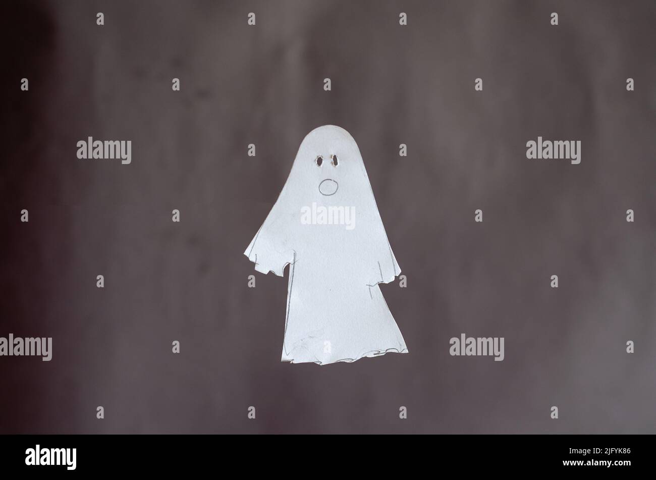 A white paper ghost against a gray background. Halloween paraphernalia ...