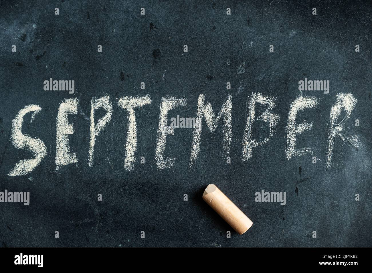 September. Name of the first autumn month written in yellow chalk on a ...