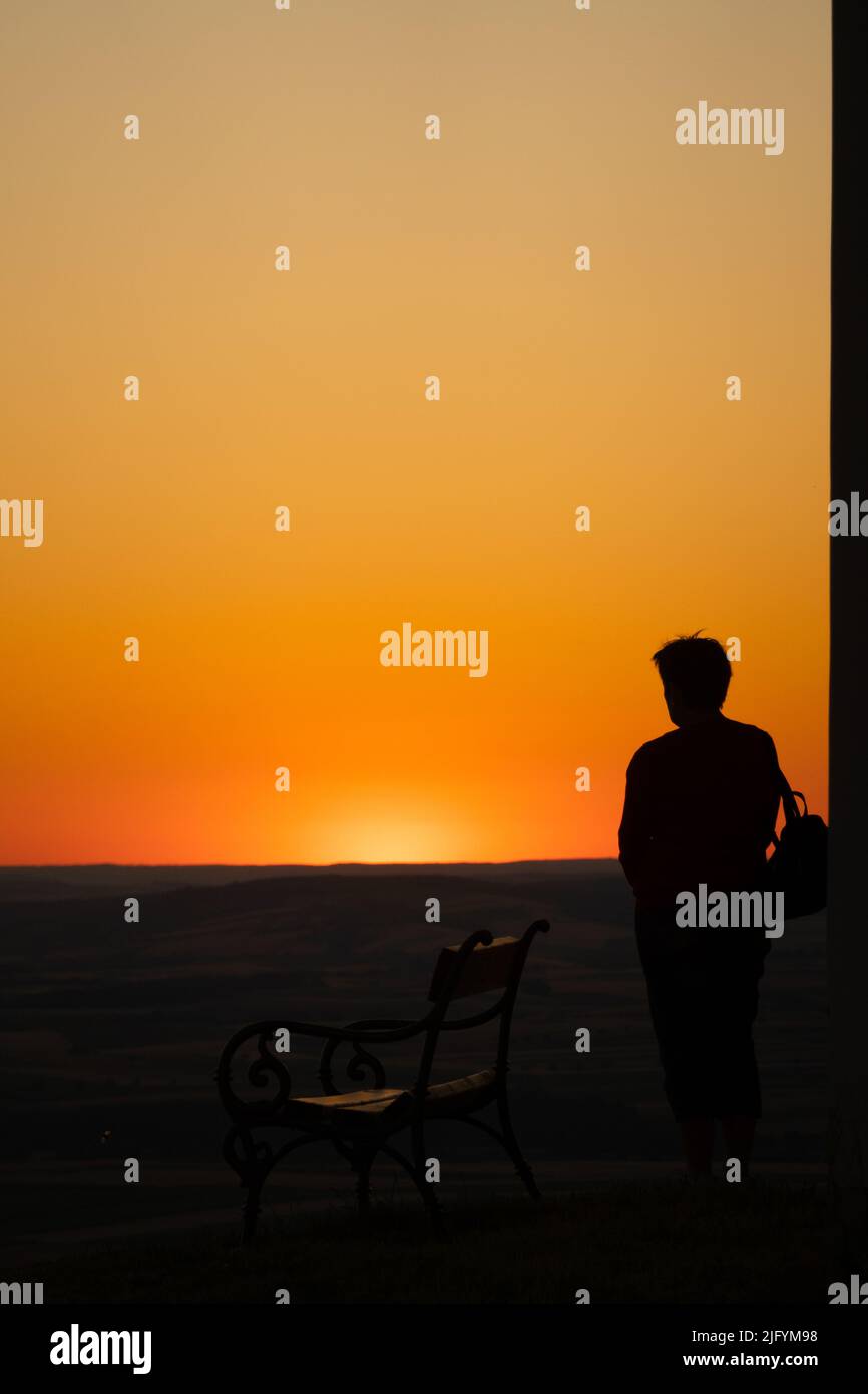 a lonely person watching the sunset and thinking about the day Stock ...