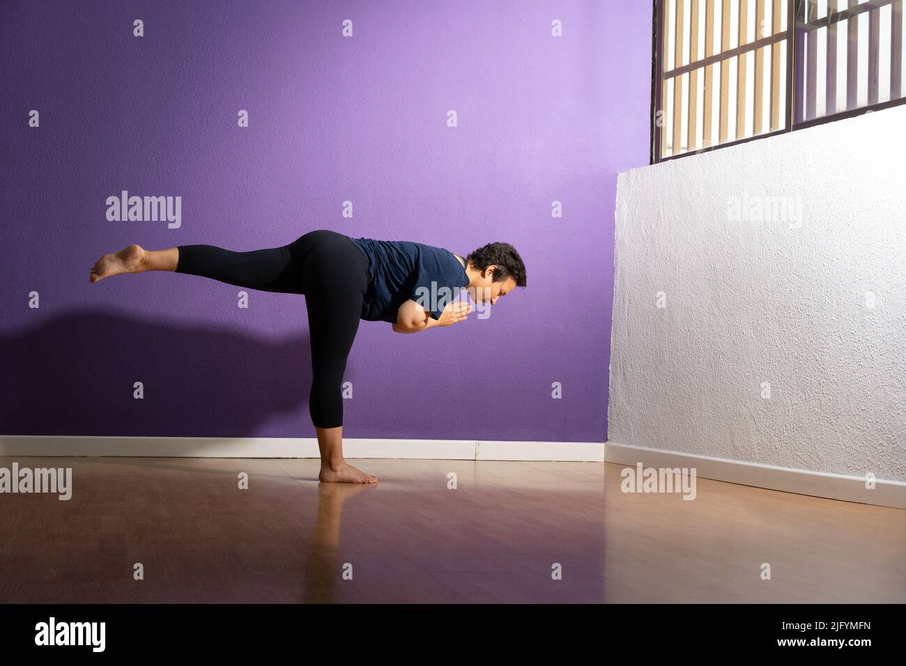 Concentrated woman practicing women practicing warrior three pose on ...