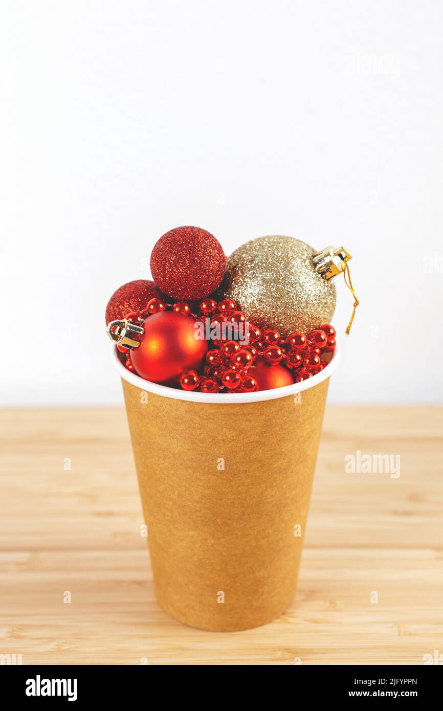 Paper coffee cup with Christmas baubles and decorations against white ...