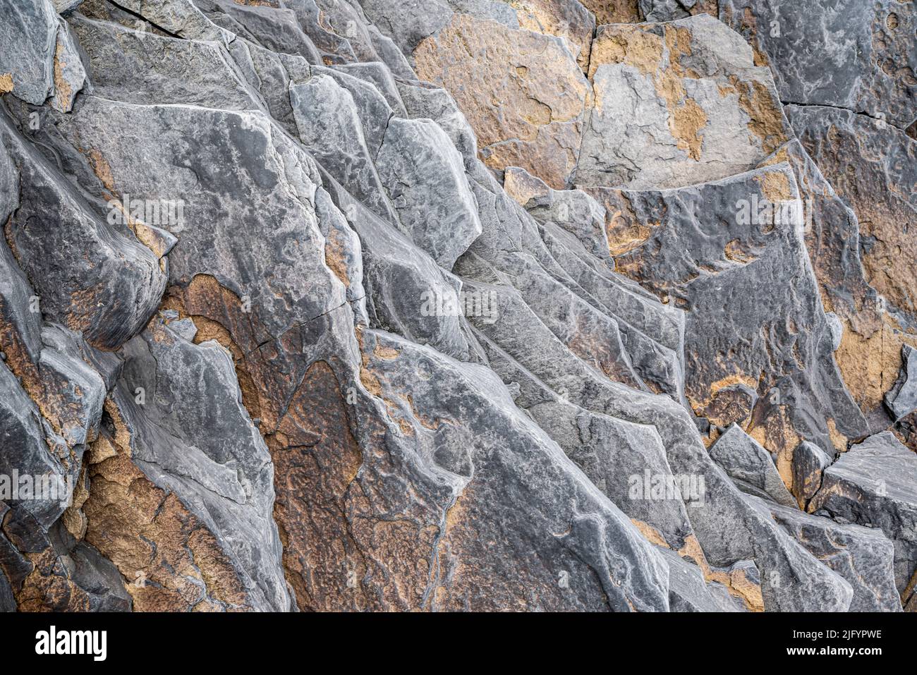 Full frame close-up of layered, slate-like structures of volcanic ...