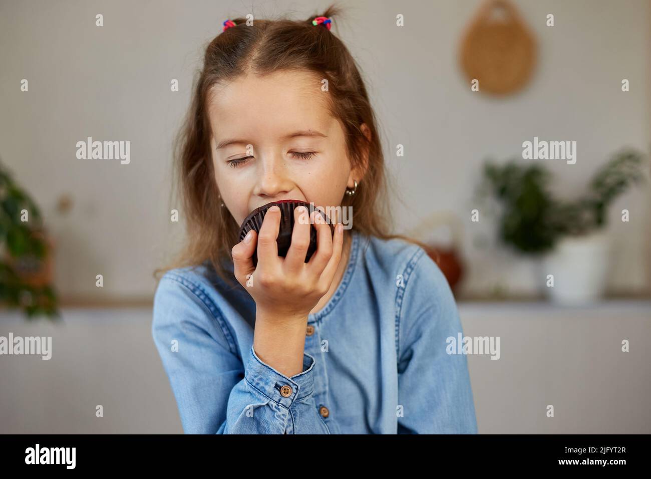 Happy little girl eats cupcake at home, smiling happy children loving ...