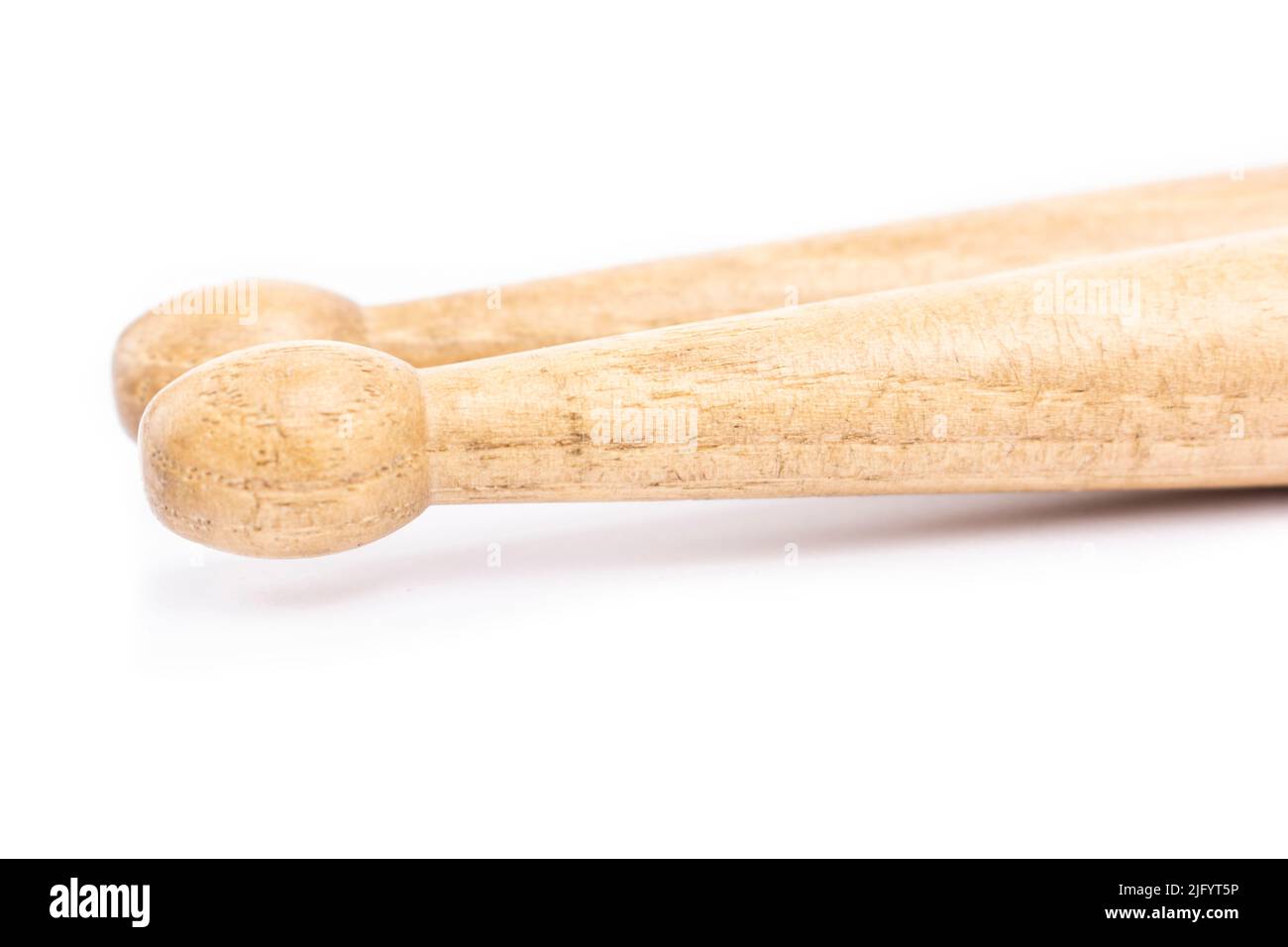 Two wooden drum sticks lying on each other isolated on white background ...