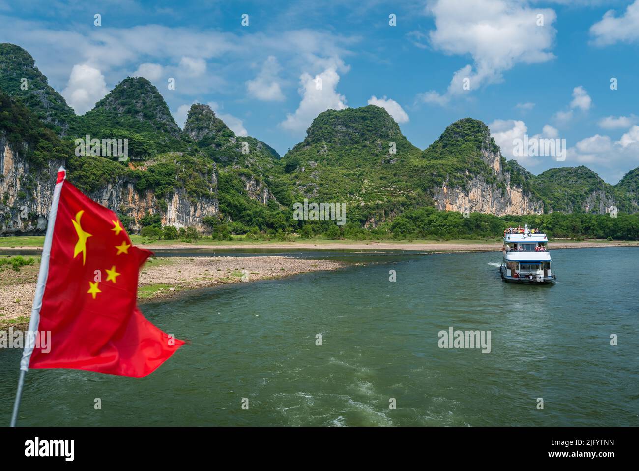 Red Chinese national flag fluttering on a mast on the deck of ...
