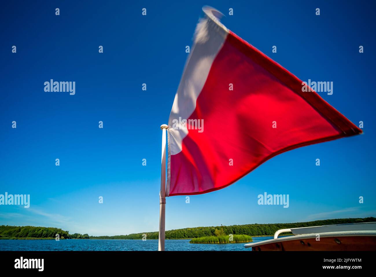 Polish flag fluttering on a boat on Jezioro Ostrowieckie in Poland ...
