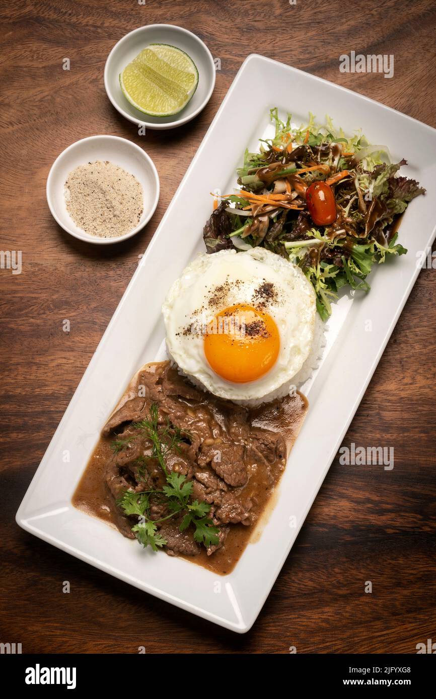 Traditional cambodian Lok Lak stir fried beef with rice meal on wood ...