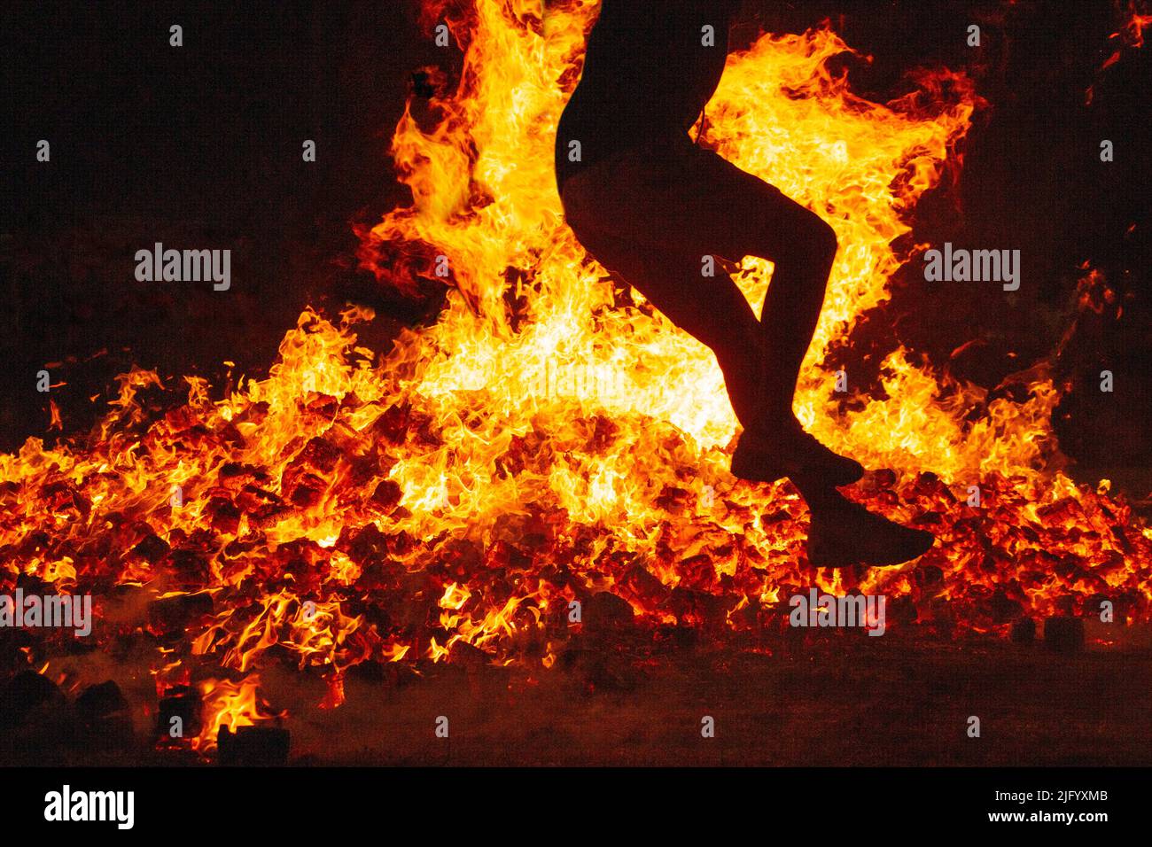 Summer solstice celebration jumping into the fire. Burning flames ...