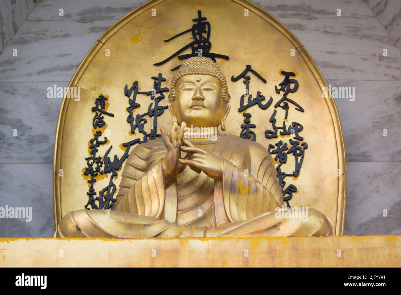 A closeup of a golden statue of Buddha sitting on a throne Stock Photo ...