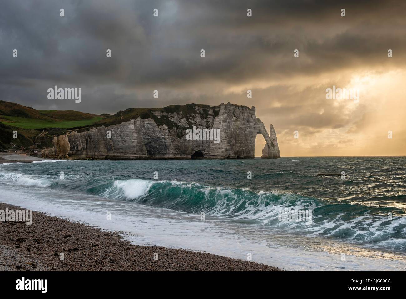 Sunset from the beach of Etretat, over the sea, the cliffs and the ...