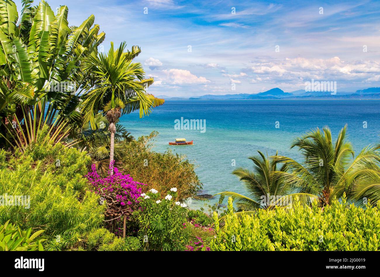 Boat seen through lush vegetation at Nosy Komba Island in the North ...