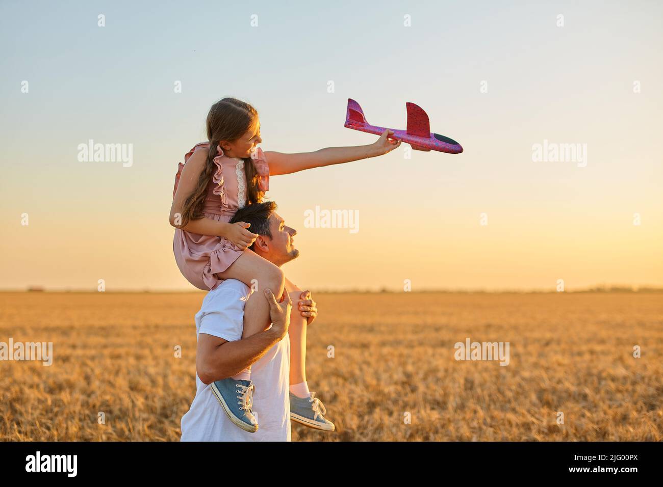 Cute girl riding on father's shoulder Stock Photo - Alamy