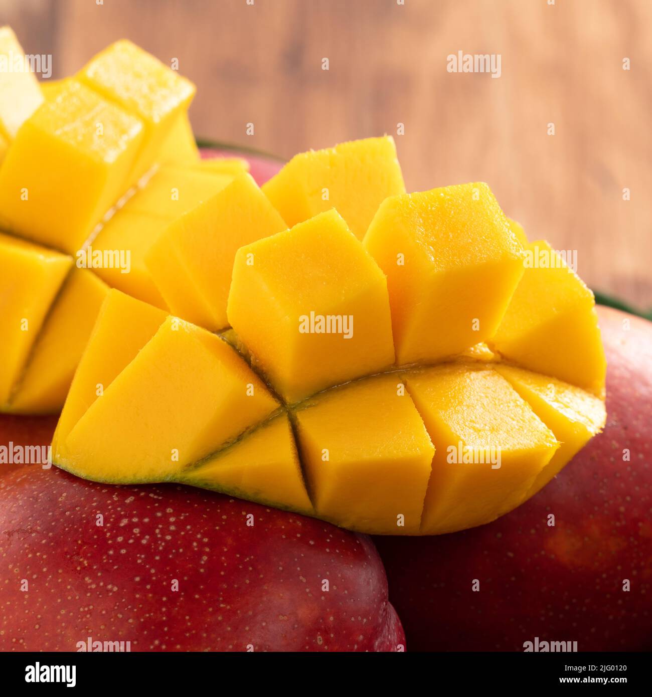 Mango. Close up of fresh ripe mango fruit with leaves over dark wooden ...