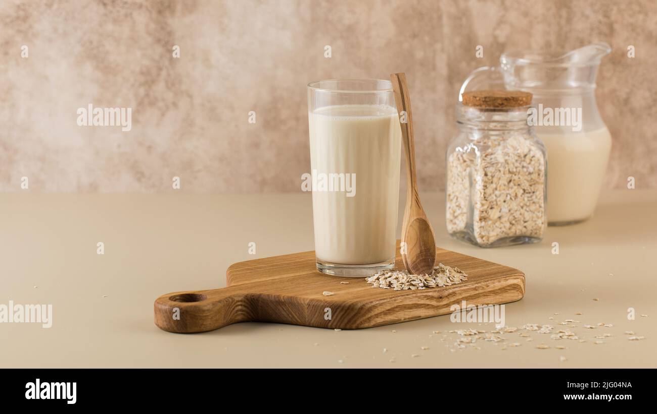 A glass of oat milk, a jug and oat flakes. The concept of alternative ...