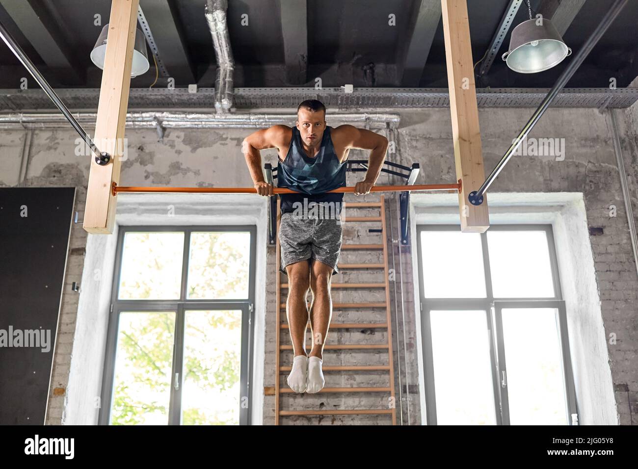 young man exercising on horizontal bar in gym Stock Photo - Alamy