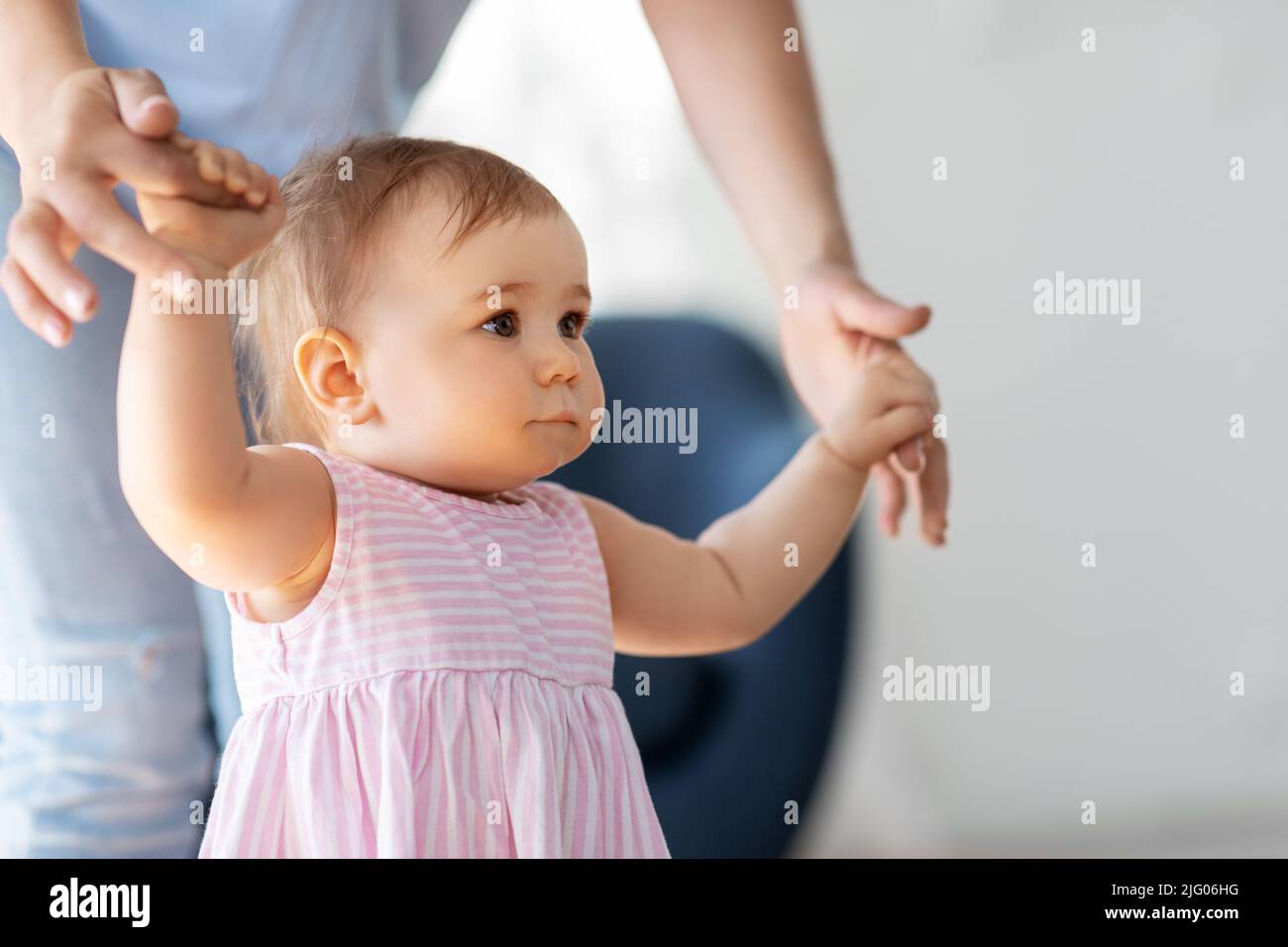 baby girl learning to walk with mother's help Stock Photo - Alamy