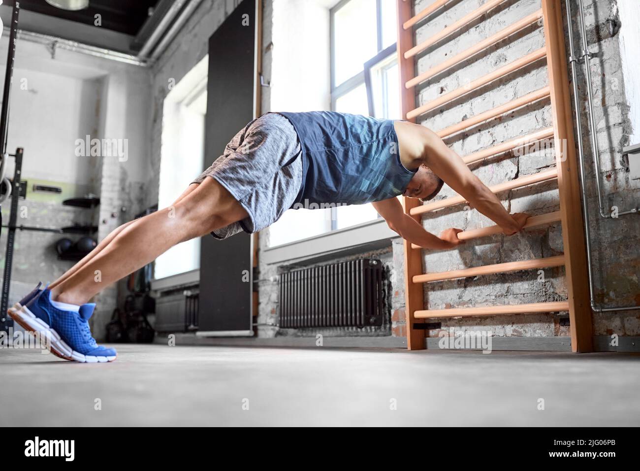 man exercising on gymnastics wall bars in gym Stock Photo - Alamy