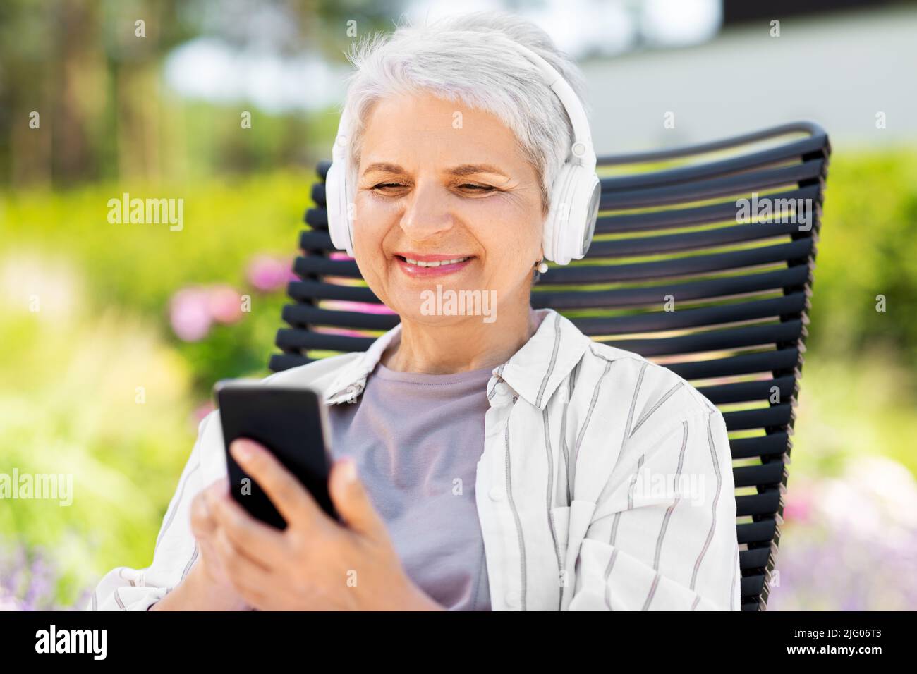 old woman with headphones and smartphone at garden Stock Photo - Alamy