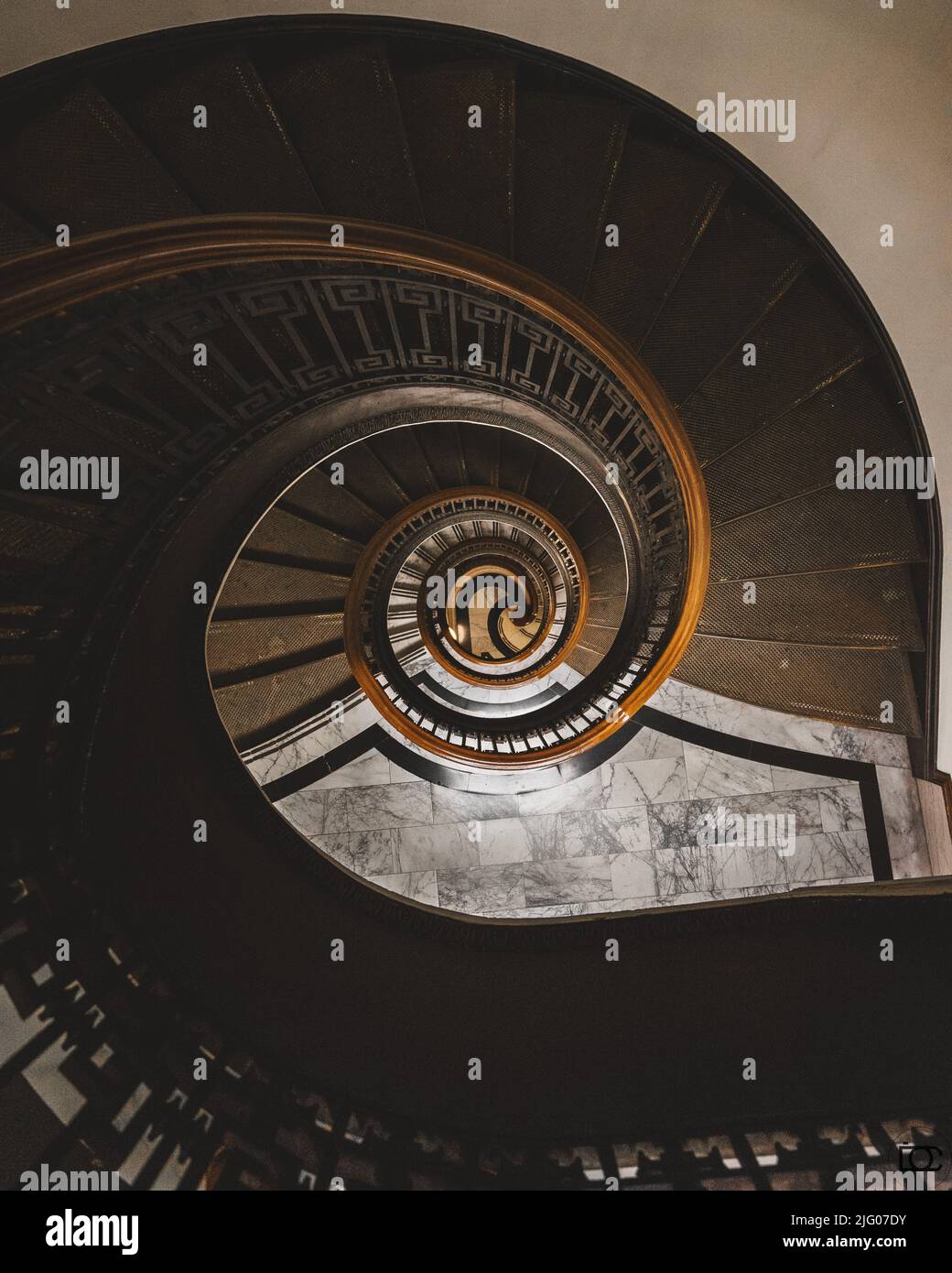 A vertical top view of spiral staircase with black and brown railings ...