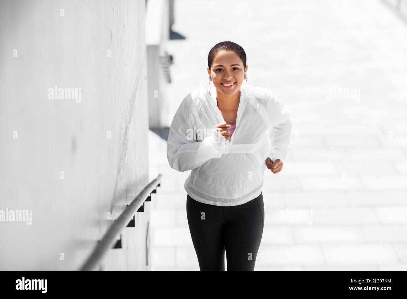 Young woman jogging upstairs in hi-res stock photography and images - Alamy