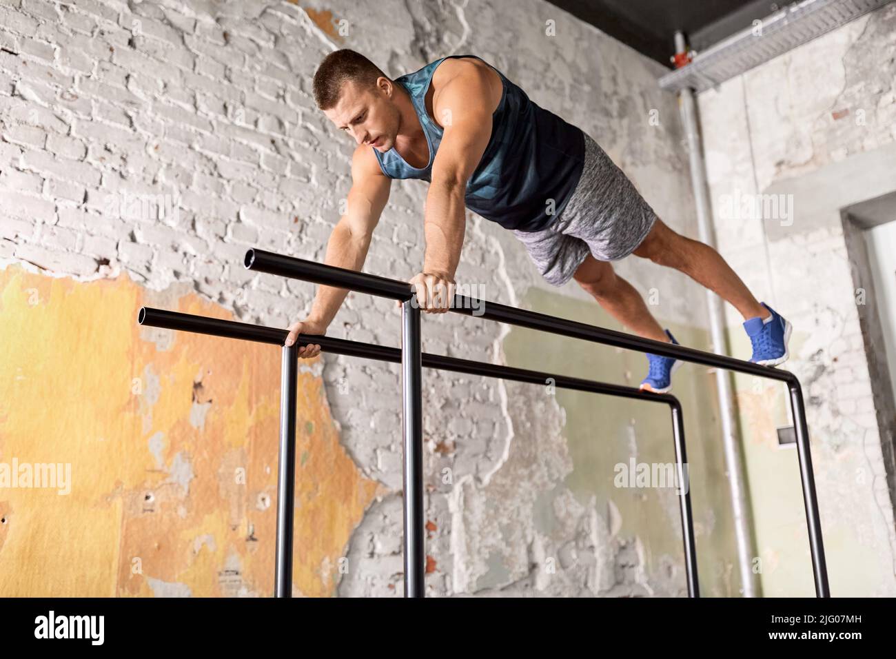 man doing push-ups on parallel bars in gym Stock Photo - Alamy