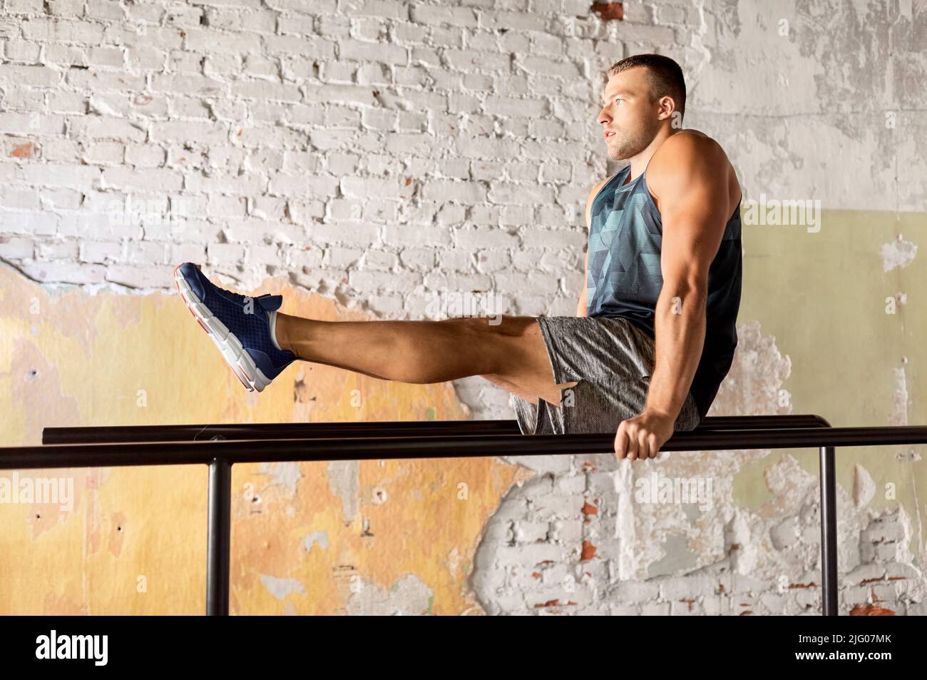 man flexing abs on parallel bars in gym Stock Photo - Alamy