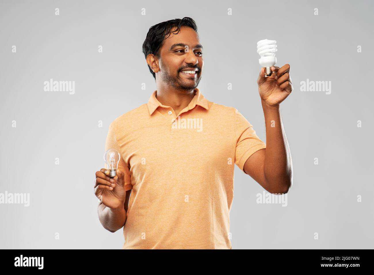 smiling indian man comparing different light bulbs Stock Photo - Alamy