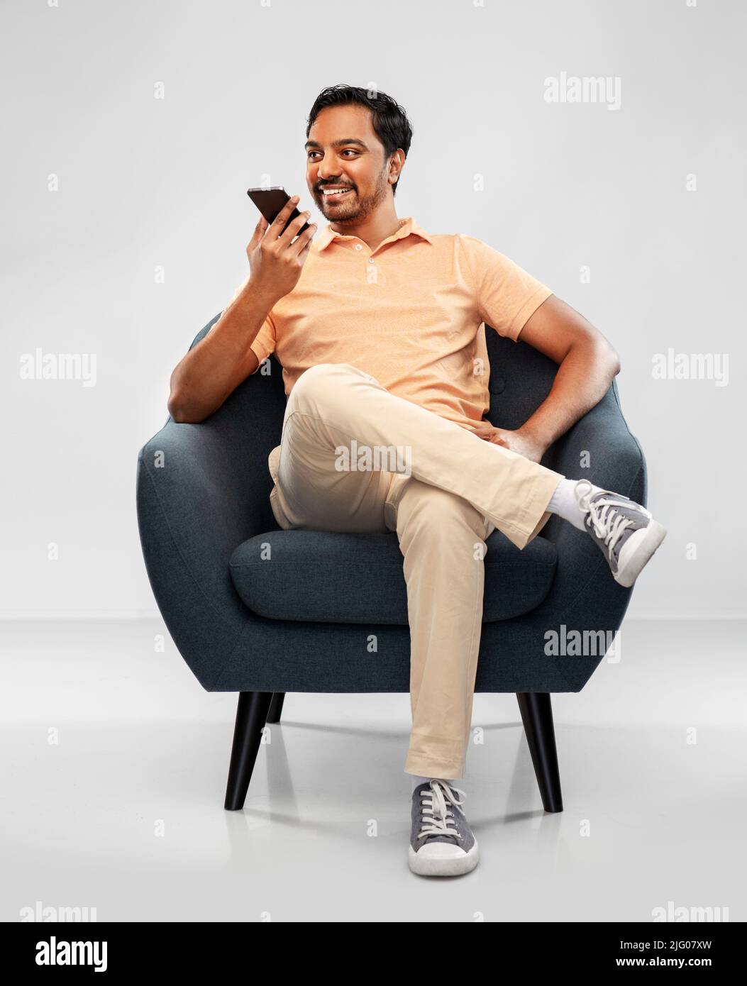 happy indian man calling on smartphone in chair Stock Photo - Alamy