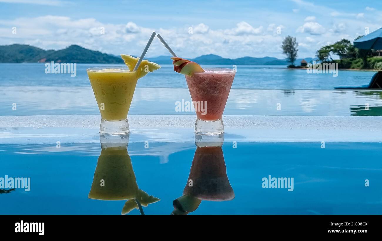 cocktails on an edge of an infinity pool of a luxury hotel. colorful ...