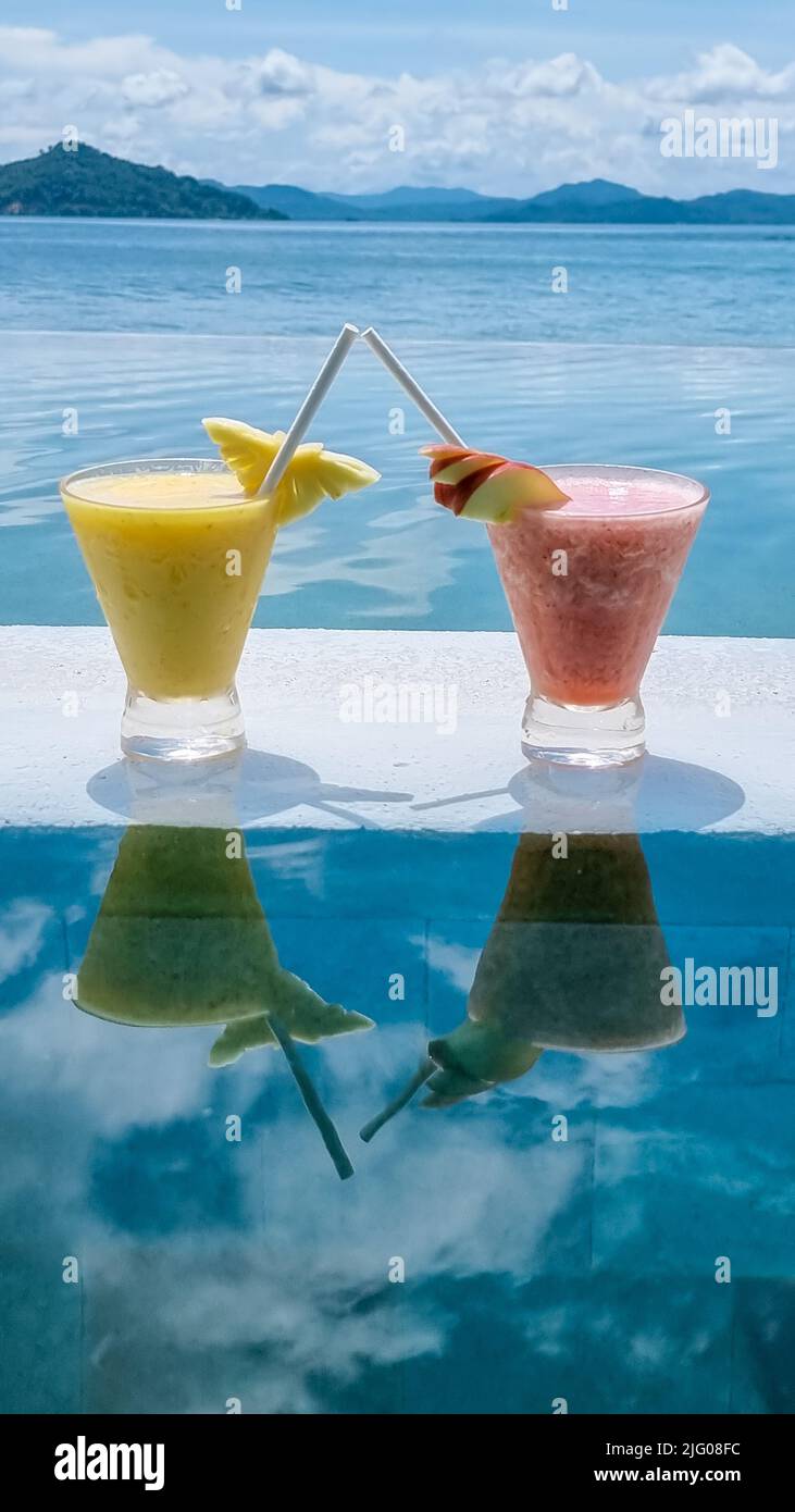 cocktails on an edge of an infinity pool of a luxury hotel. colorful ...