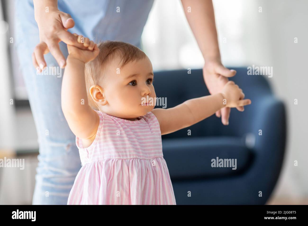 baby girl learning to walk with mother's help Stock Photo - Alamy