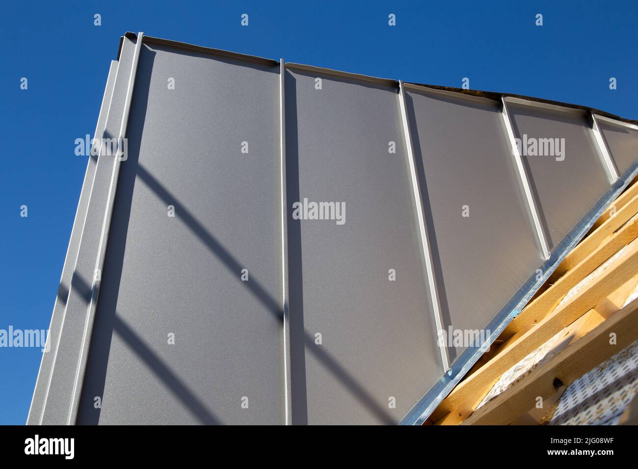 New roofing of a tiled roof. The new dormer with aluminium sheathing is ...
