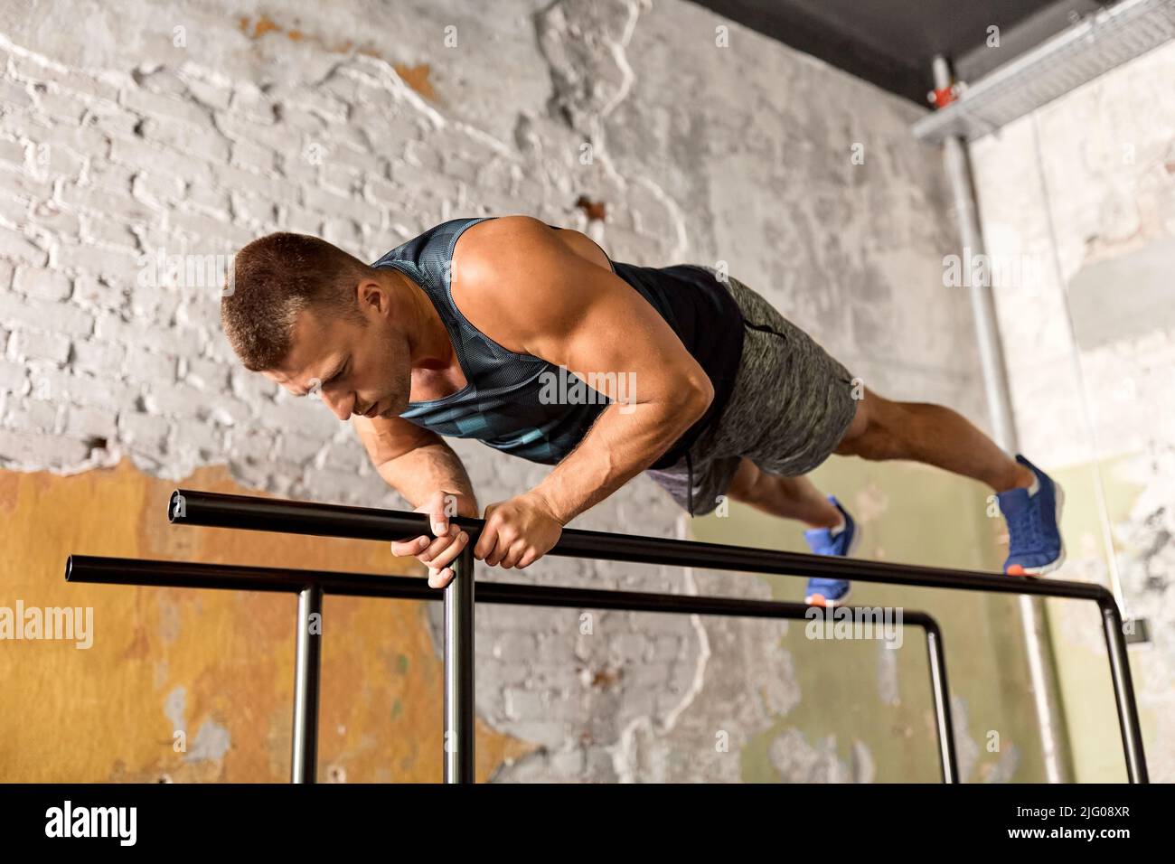 man doing push-ups on parallel bars in gym Stock Photo - Alamy