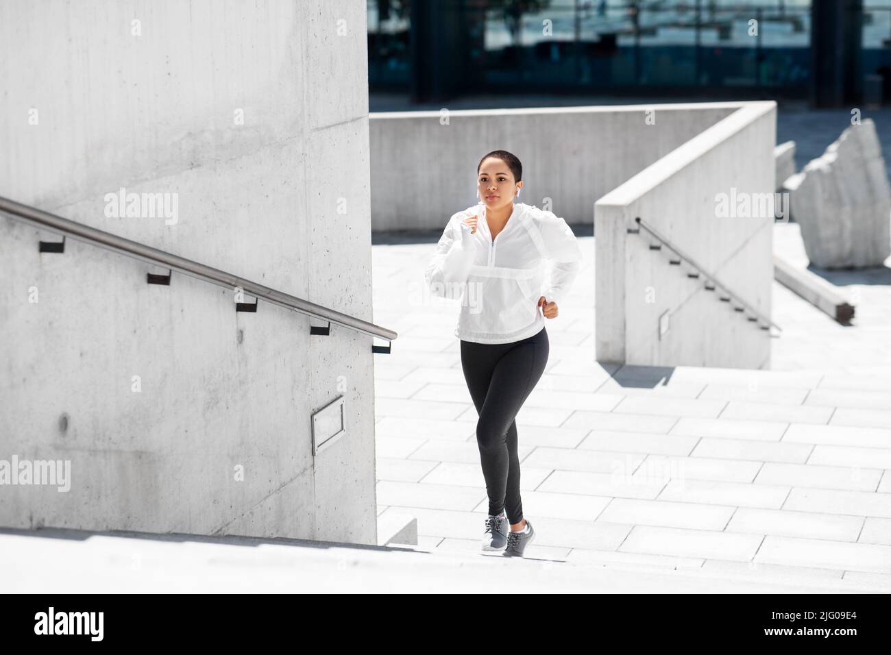 african american woman running upstairs outdoors Stock Photo - Alamy