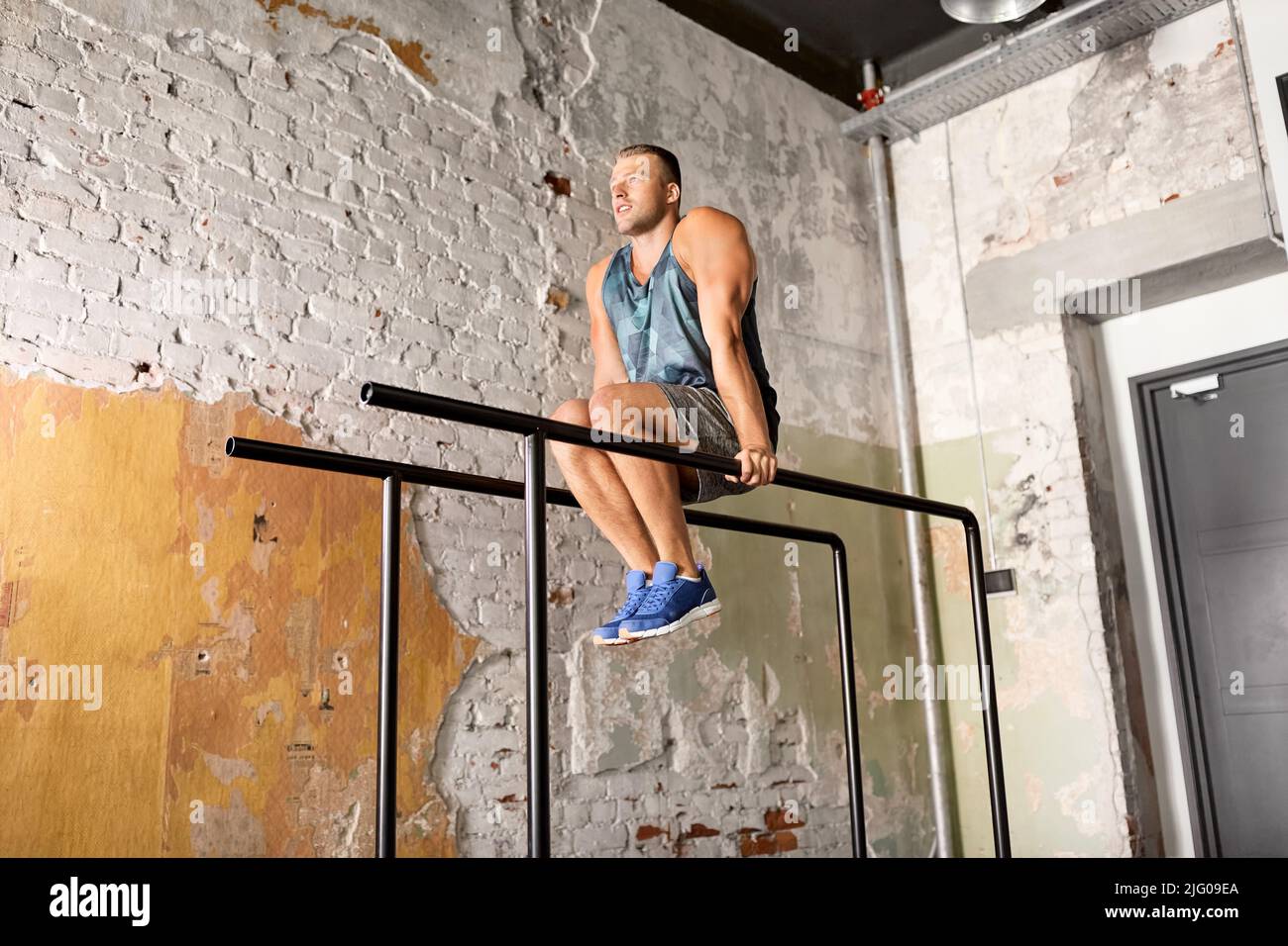 man flexing abs on parallel bars in gym Stock Photo - Alamy