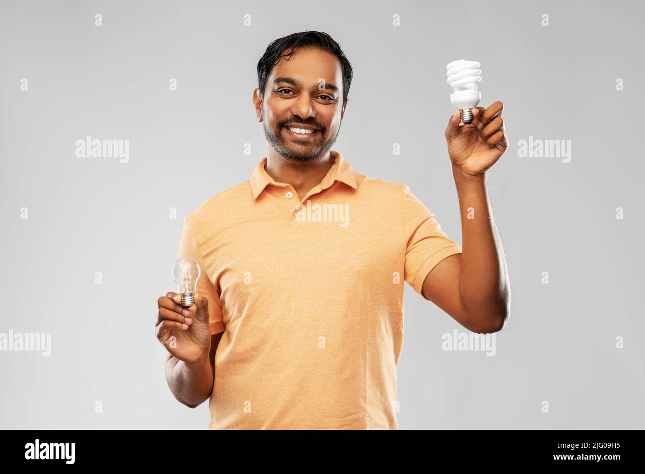 smiling indian man comparing different light bulbs Stock Photo - Alamy