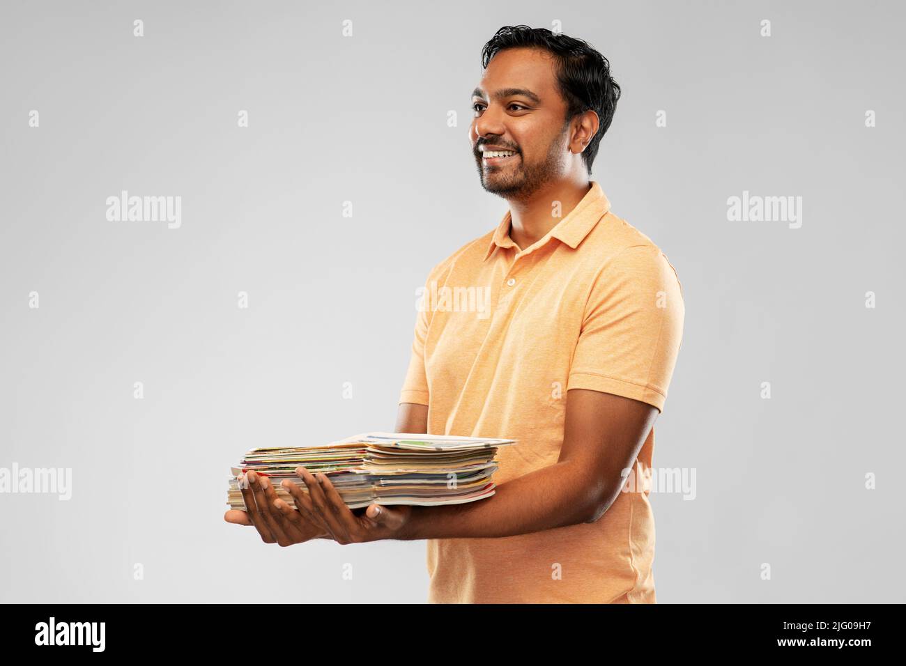 smiling young indian man sorting paper waste Stock Photo - Alamy