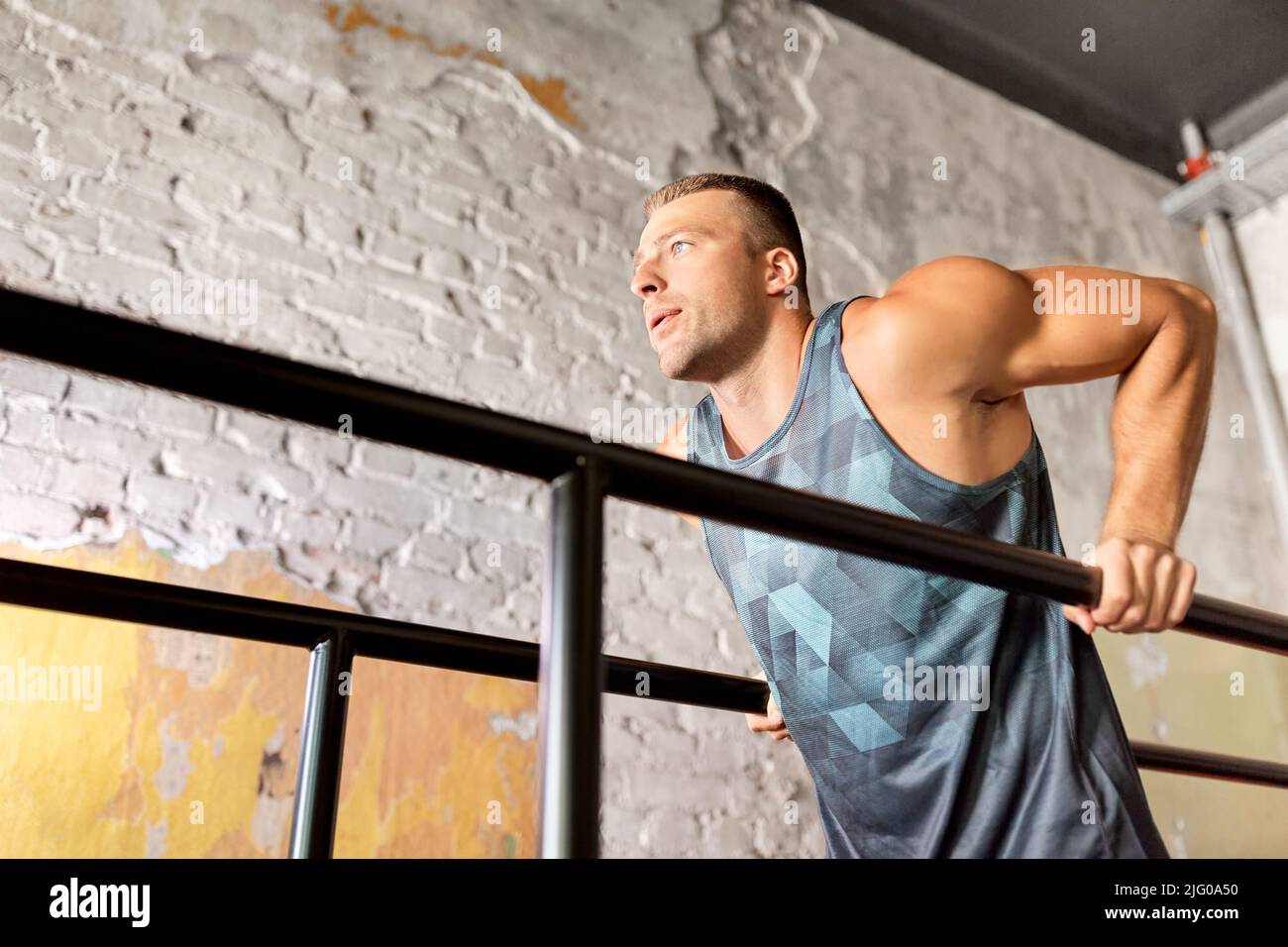 man doing triceps dip on parallel bars in gym Stock Photo - Alamy