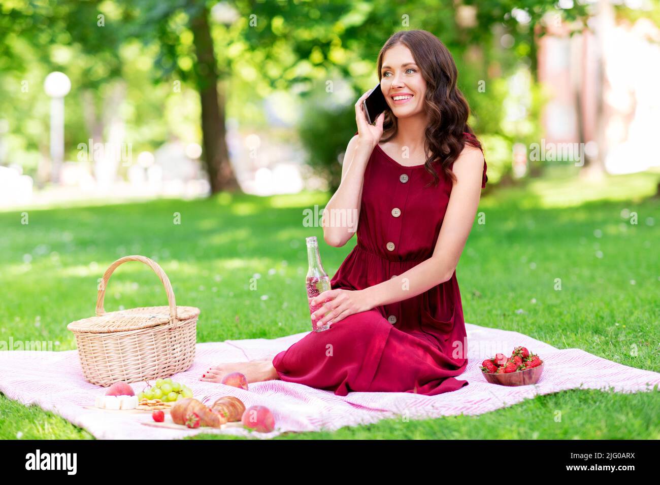 woman calling on smartphone on picnic at park Stock Photo - Alamy