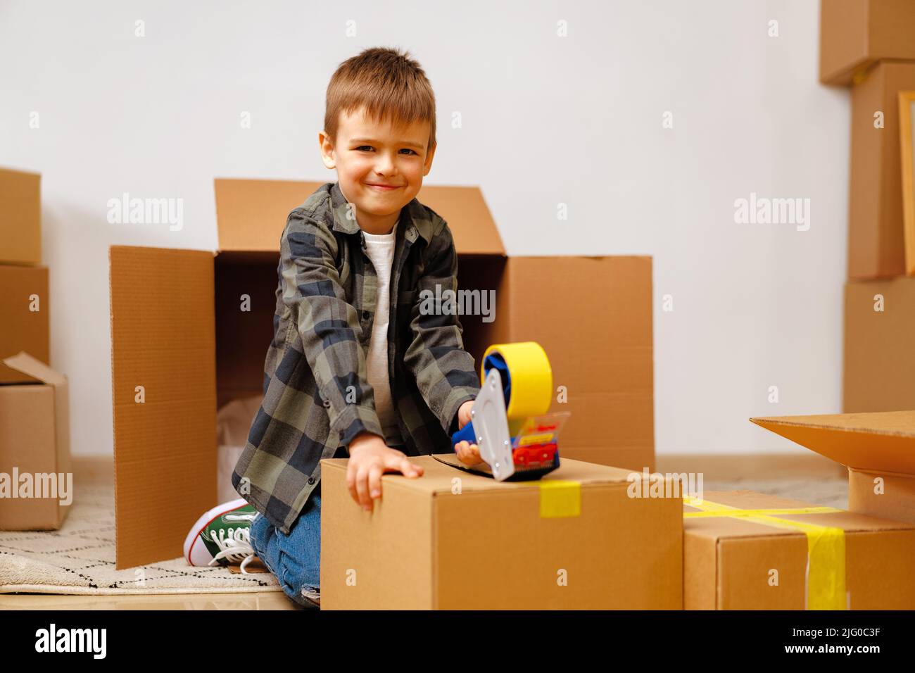 Little boy packing a moving box for a new home Stock Photo - Alamy