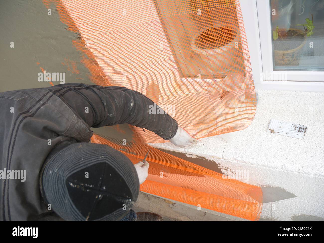 Contractor plastering wall with fiberglass mesh, plaster mesh after ...