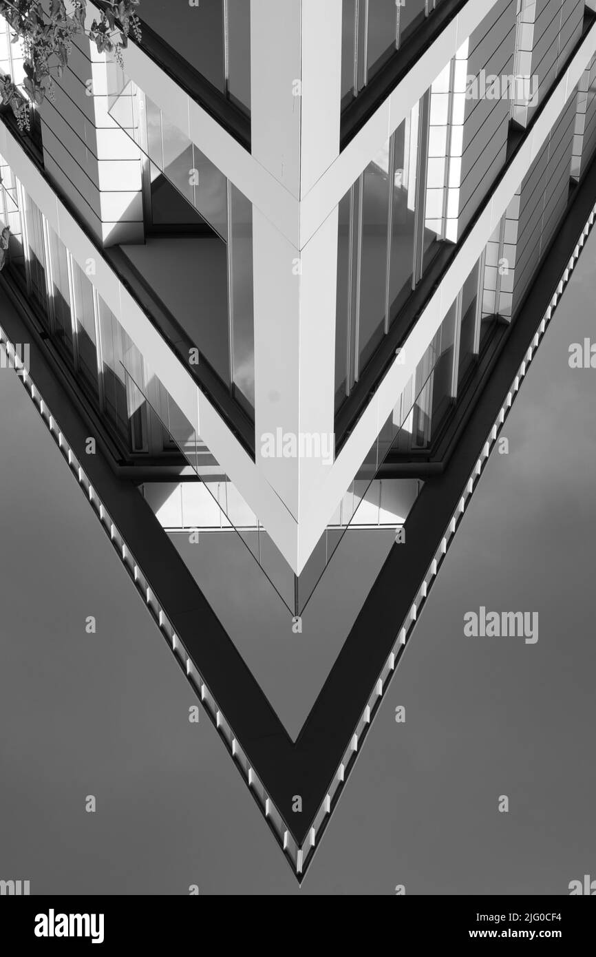 A low angle of a modern building against a sky shot in grayscale upside ...