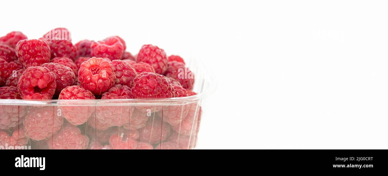 Fresh raspberries in a transparent container on a white isolated ...